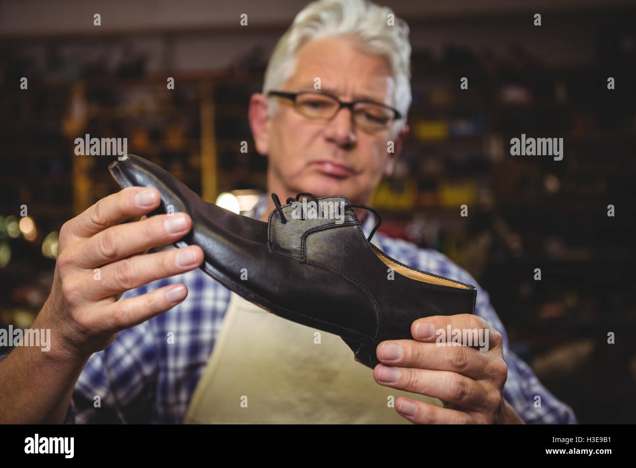 Shoemaker examining a shoe Stock Photo - Alamy