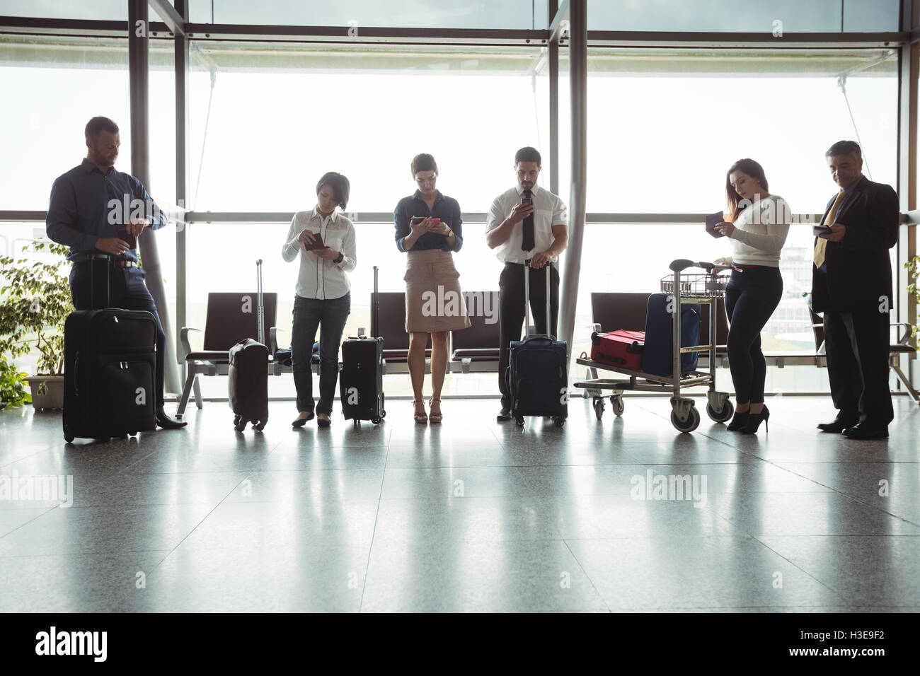 Business people using mobile phone in waiting area Stock Photo - Alamy