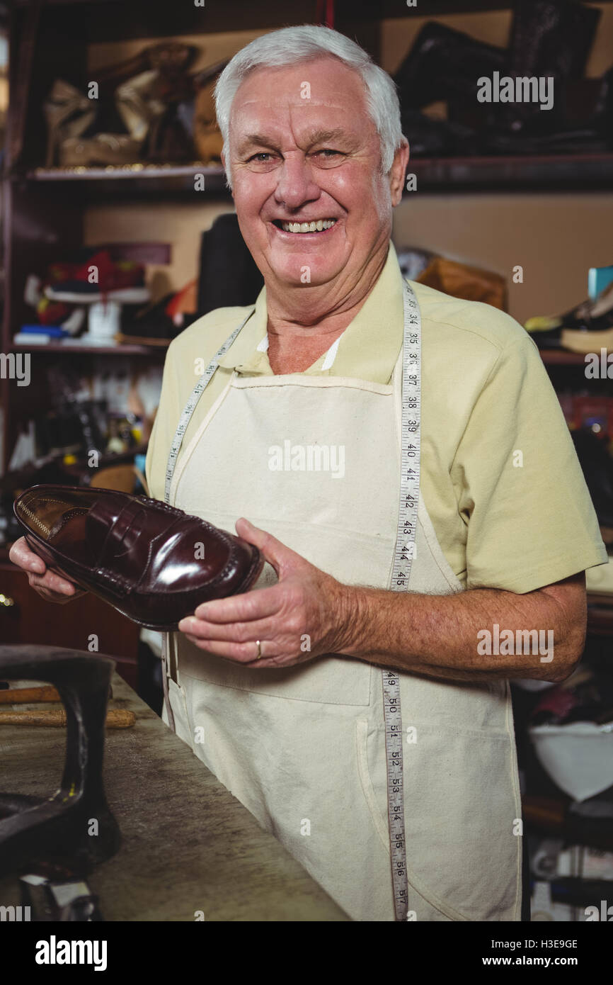 Portrait of shoemaker holding a shoe Stock Photo - Alamy
