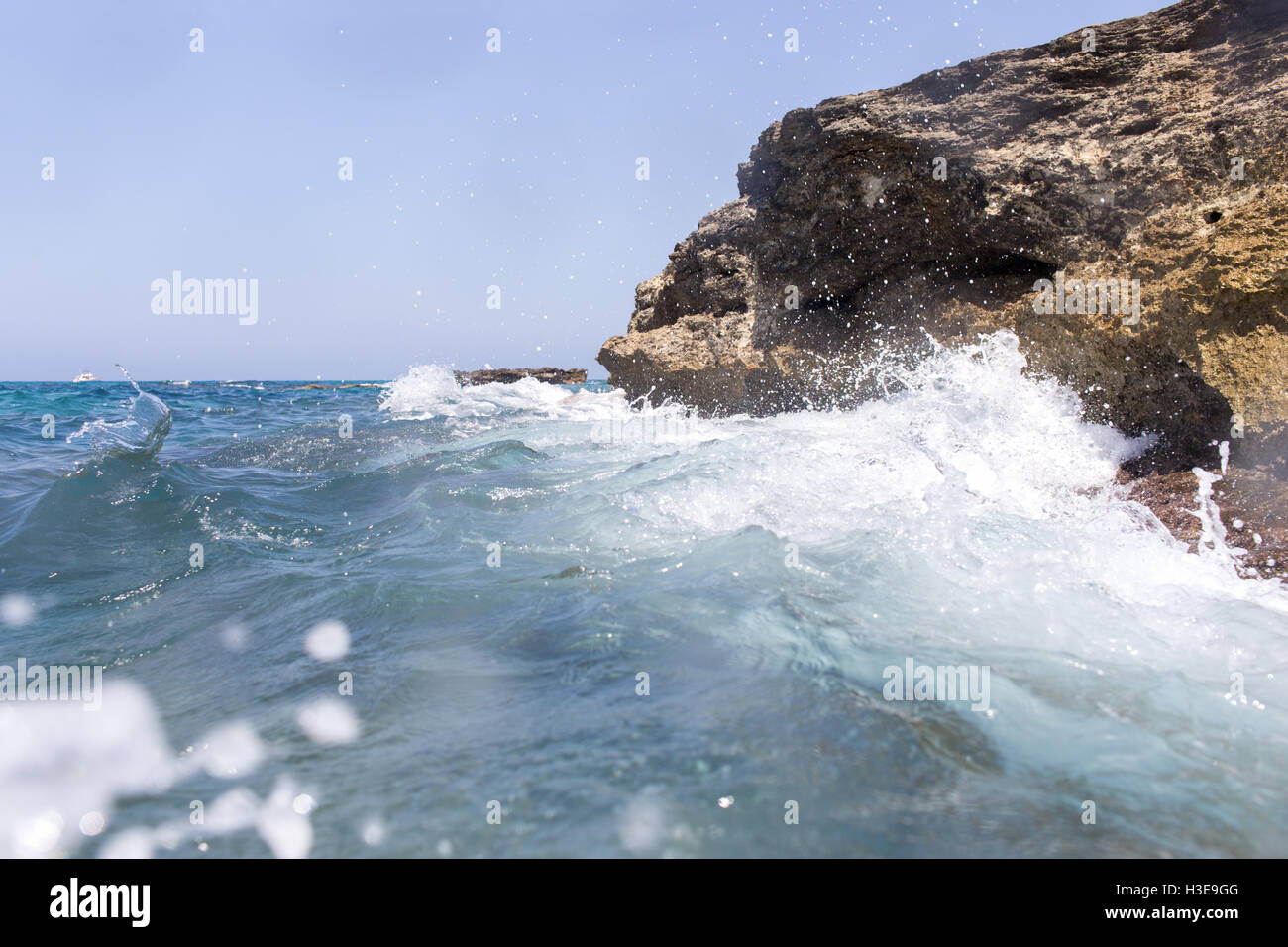 Sea wave splashing over the shore rocks with a high sea spray Stock ...