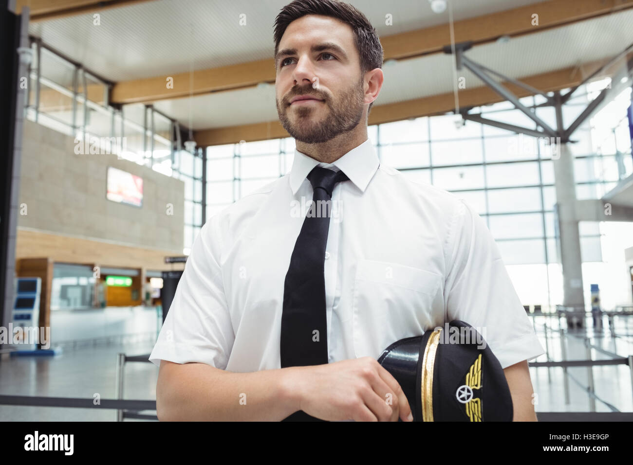 Pilot standing in airport terminal Stock Photo - Alamy