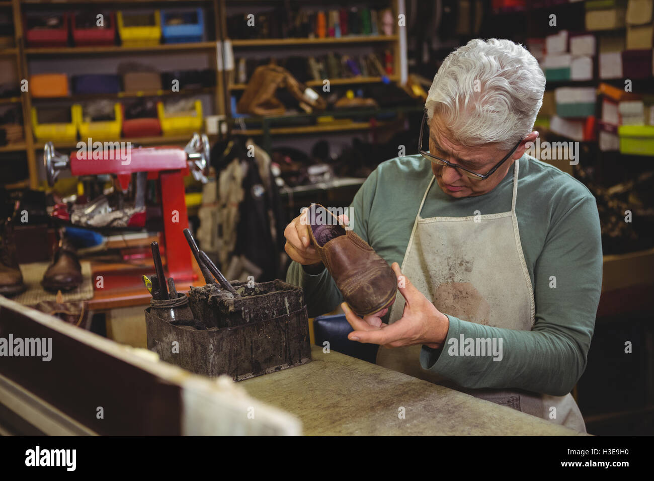 Shoemaker examining a shoe Stock Photo - Alamy