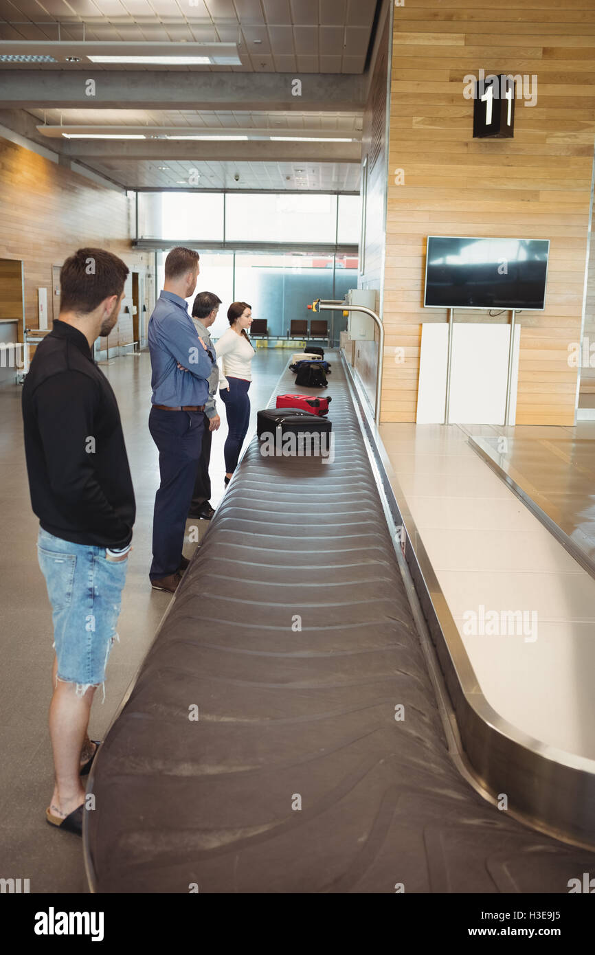 People waiting for luggage in baggage claim area Stock Photo - Alamy