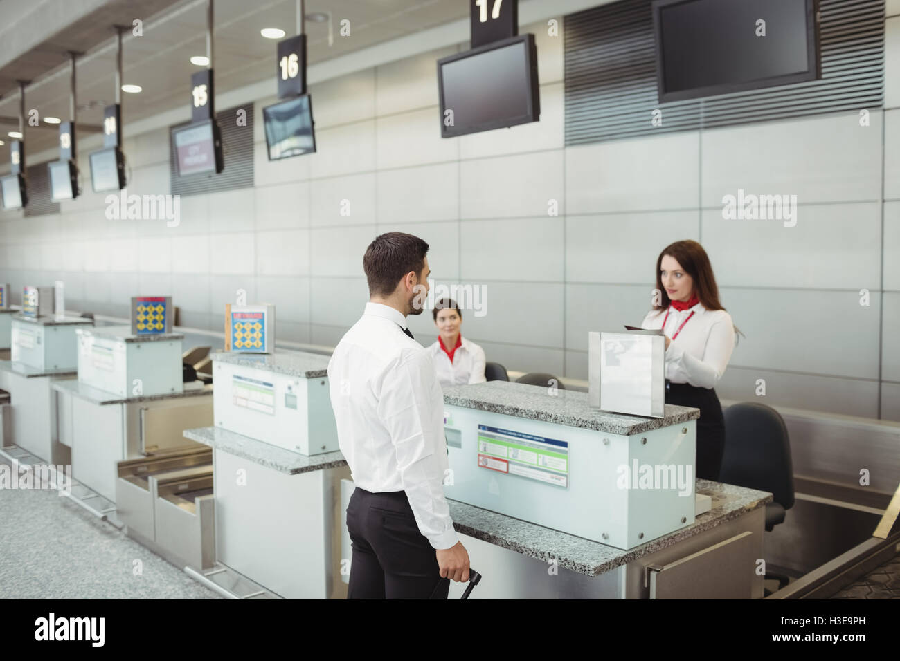 Airline check-in attendant checking passport of passenger Stock Photo ...