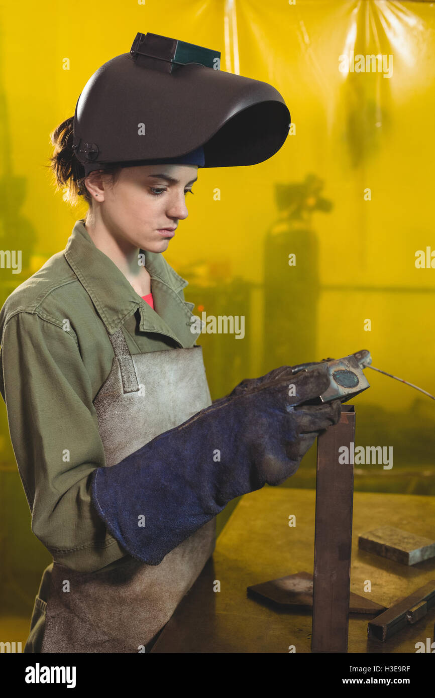 Female welder examining a piece of metal Stock Photo - Alamy