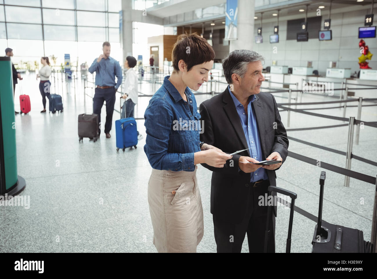 Business man and woman checking their passport Stock Photo - Alamy