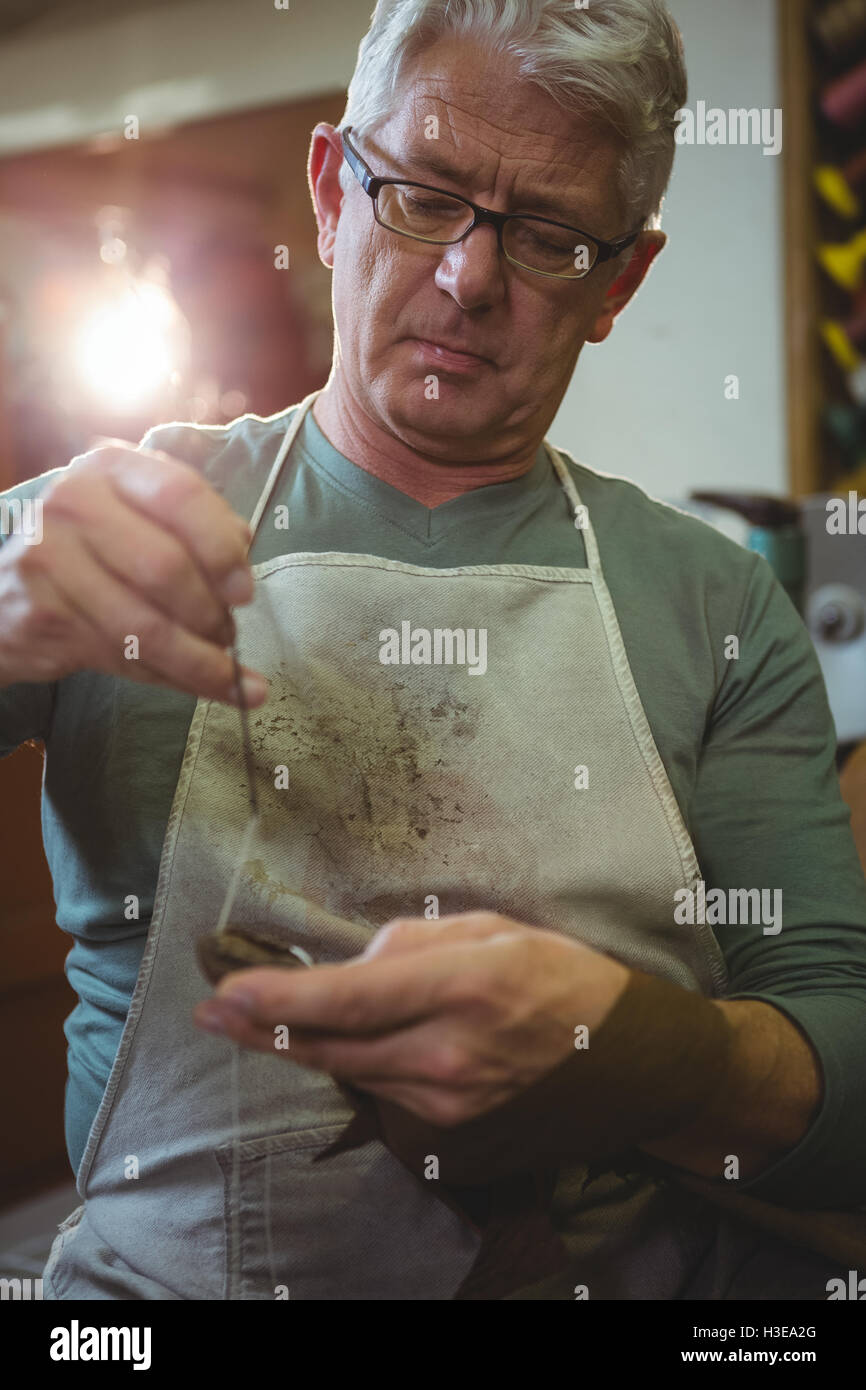 Shoemaker stitching shoe sole with needle Stock Photo - Alamy