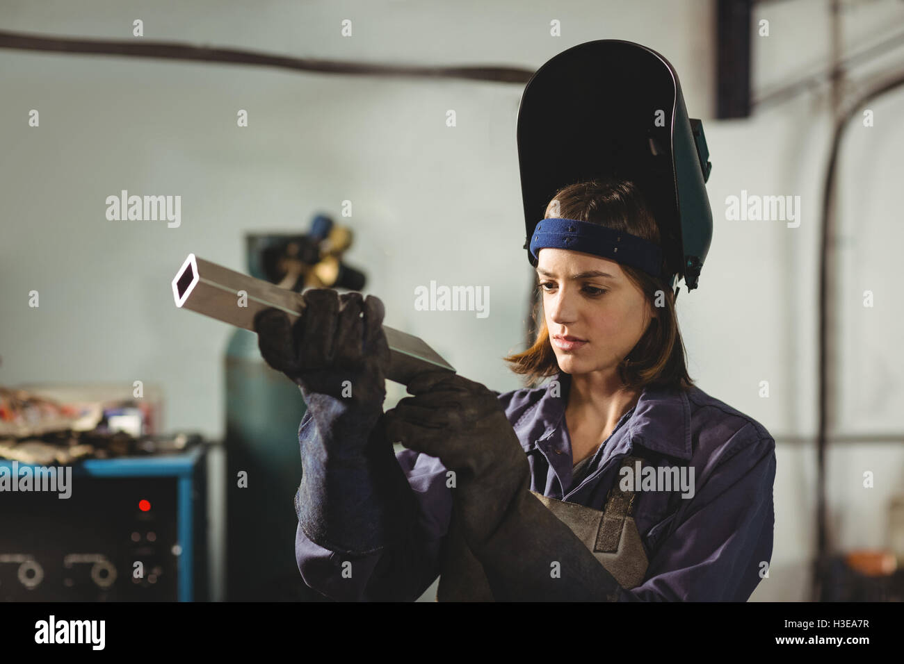 Female welder examining a piece of metal Stock Photo - Alamy