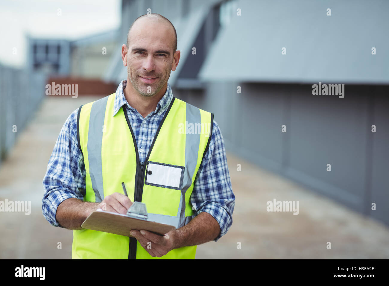 Portrait of construction worker writing on clipboard Stock Photo - Alamy