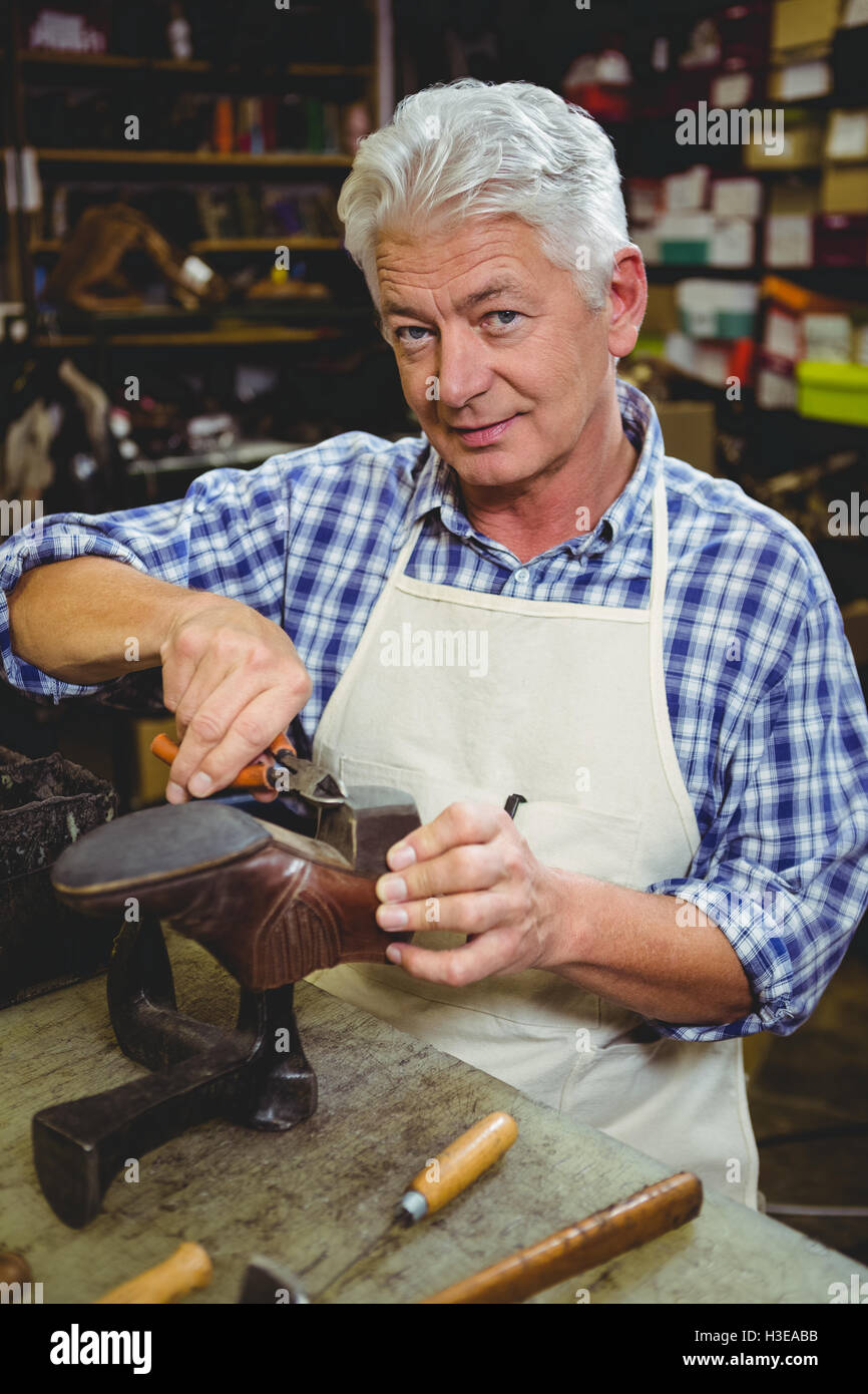 Portrait of shoemaker repairing a shoe Stock Photo - Alamy