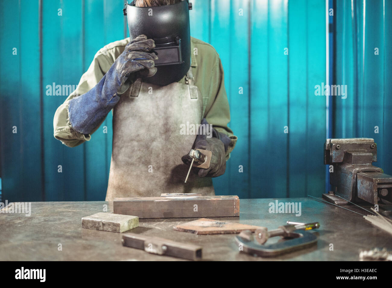 Female welder holding welding arch Stock Photo - Alamy