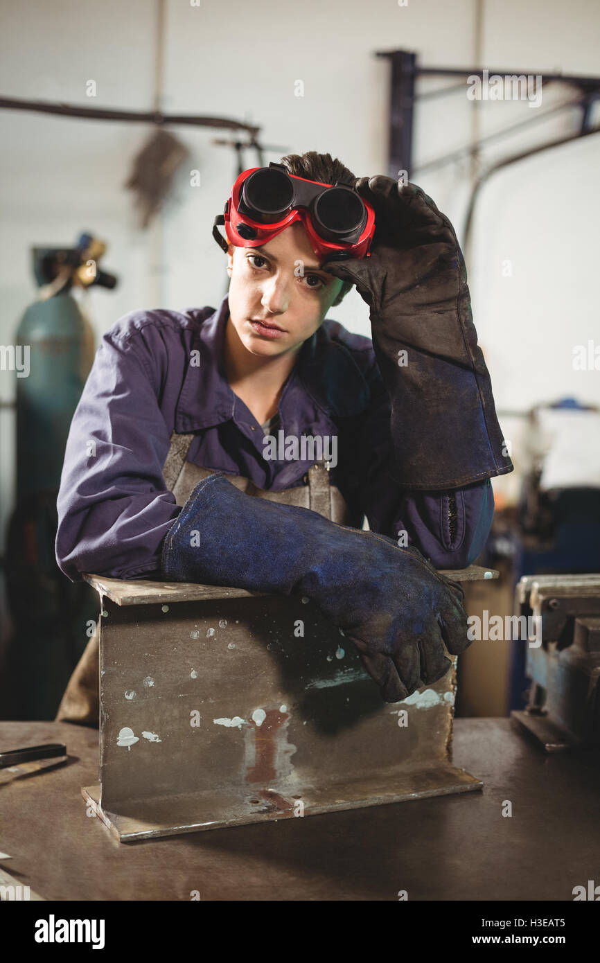 Portrait of female welder standing with a piece of metal Stock Photo ...