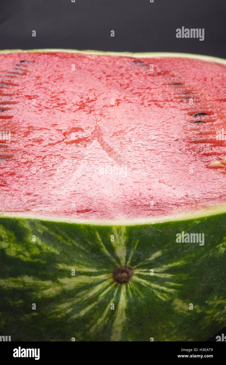 half of ripe watermelon on a black background Stock Photo - Alamy