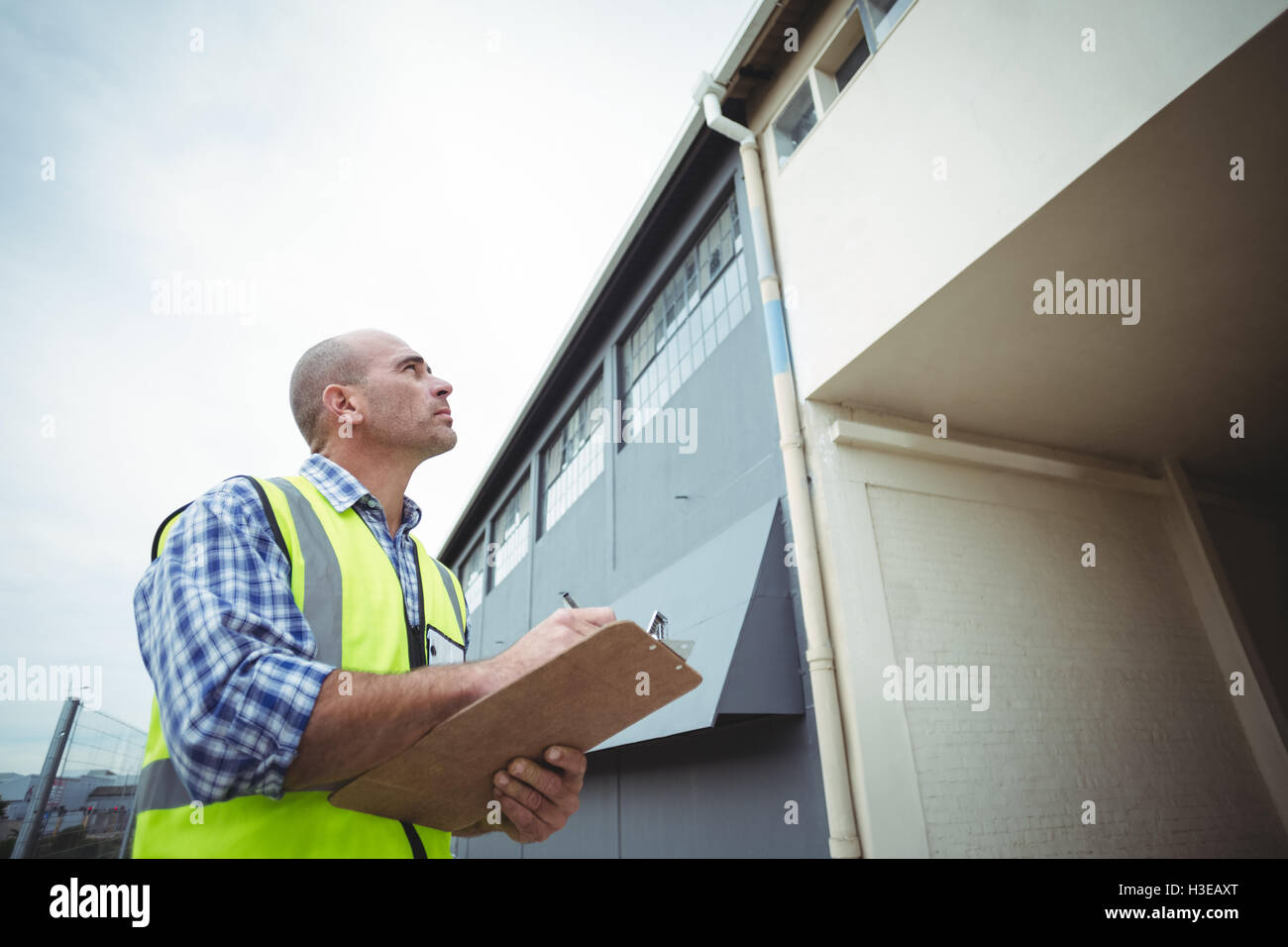 Construction worker writing on a clipboard Stock Photo - Alamy