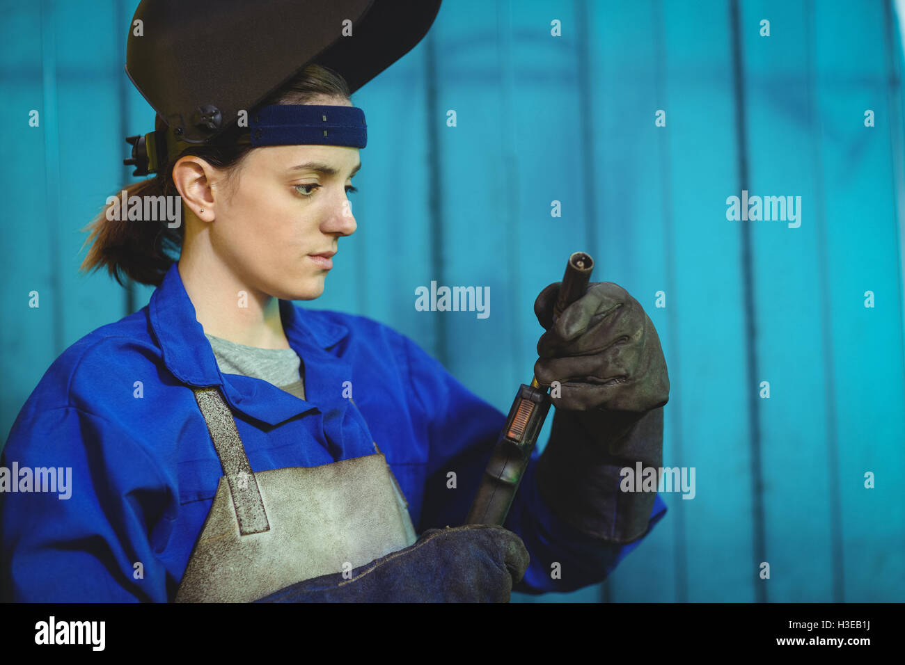 Female welder examining a welding torch Stock Photo - Alamy