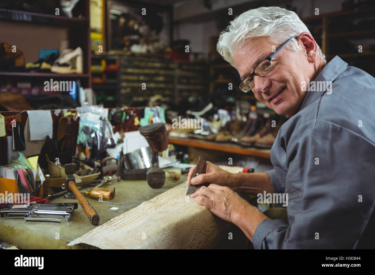Portrait of shoemaker cutting a piece of material Stock Photo - Alamy