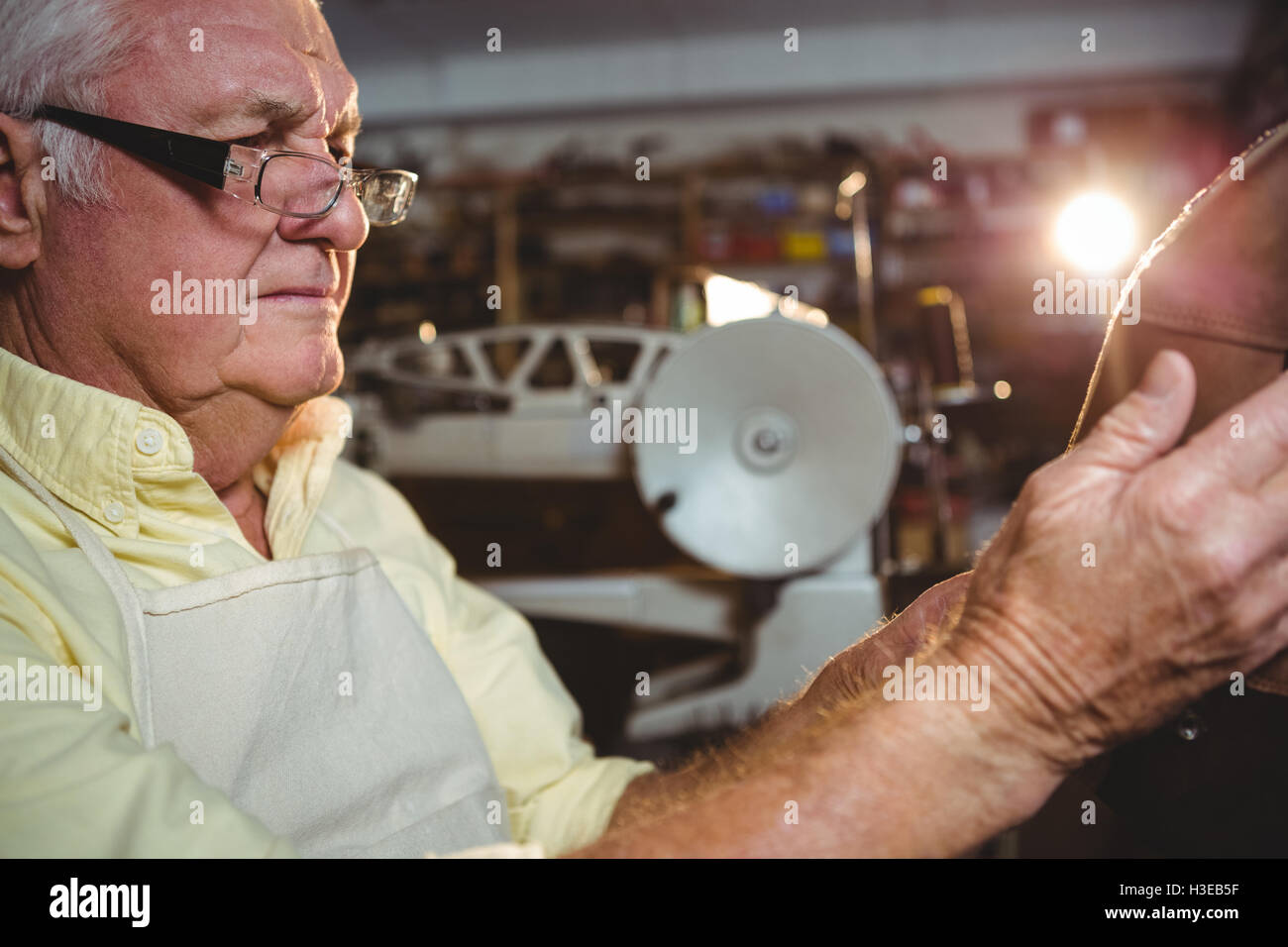 Shoemaker examining a shoe Stock Photo - Alamy