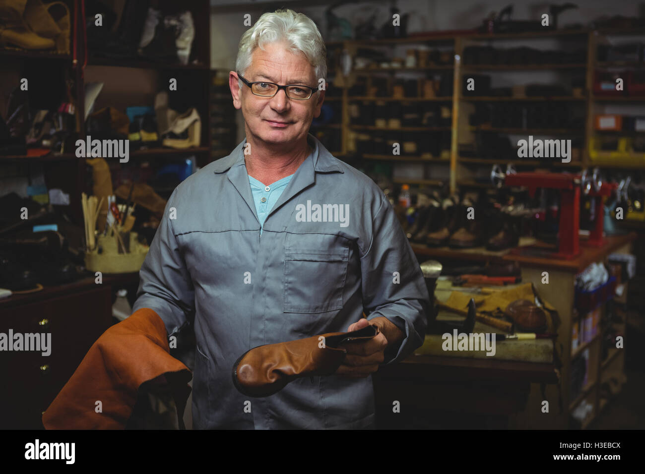 Portrait of shoemaker holding a boot and piece of material Stock Photo ...