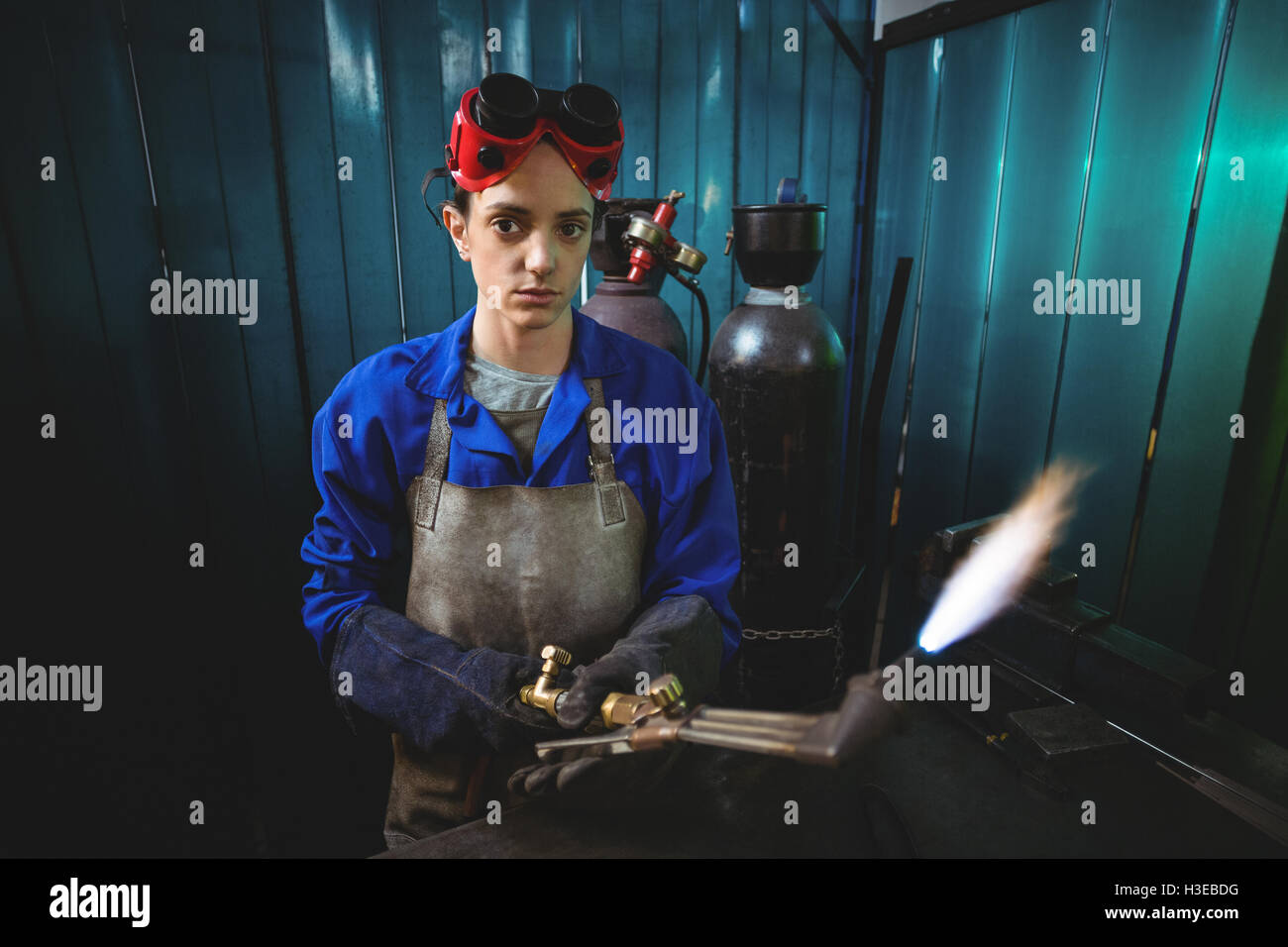 Female welder holding welding torch Stock Photo - Alamy