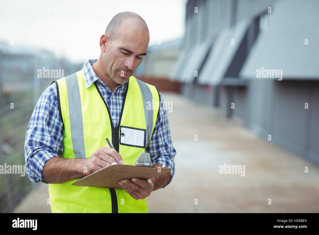 Construction worker writing on a clipboard Stock Photo - Alamy