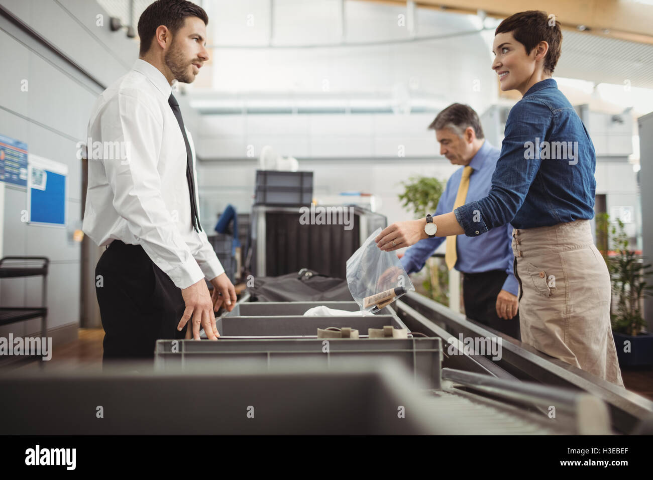Passenger putting plastic bag into tray for security check Stock Photo ...