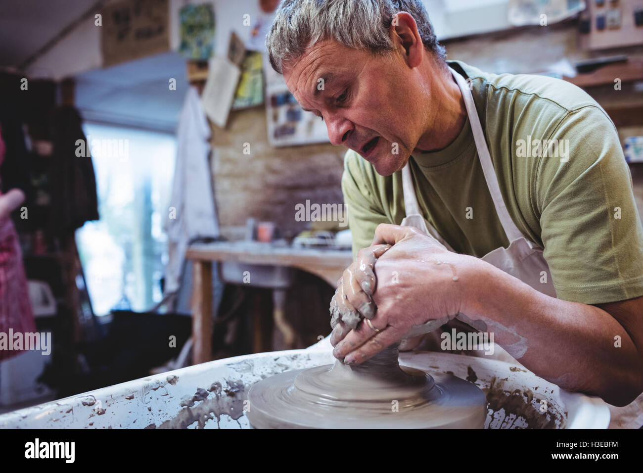 Concentrated man making ceramic product Stock Photo - Alamy