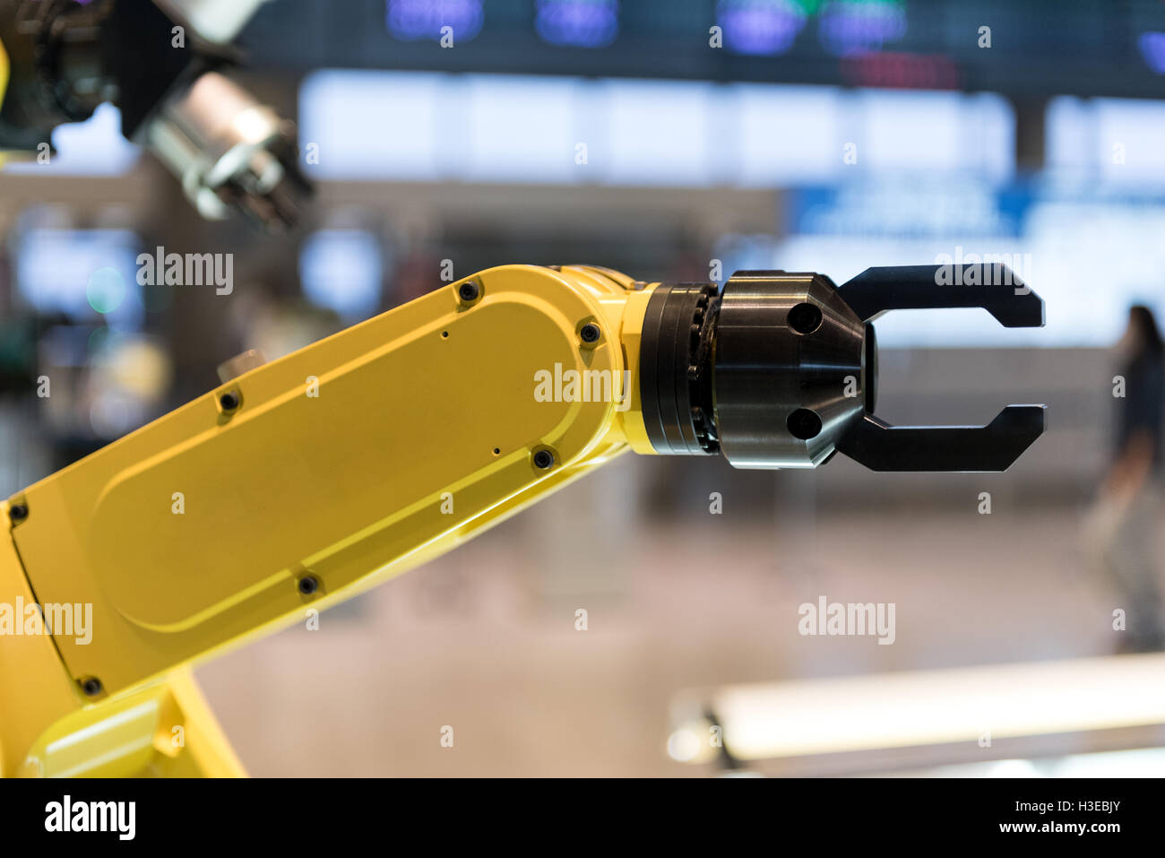 A yellow robotic arm isolated on a blurry background Stock Photo - Alamy