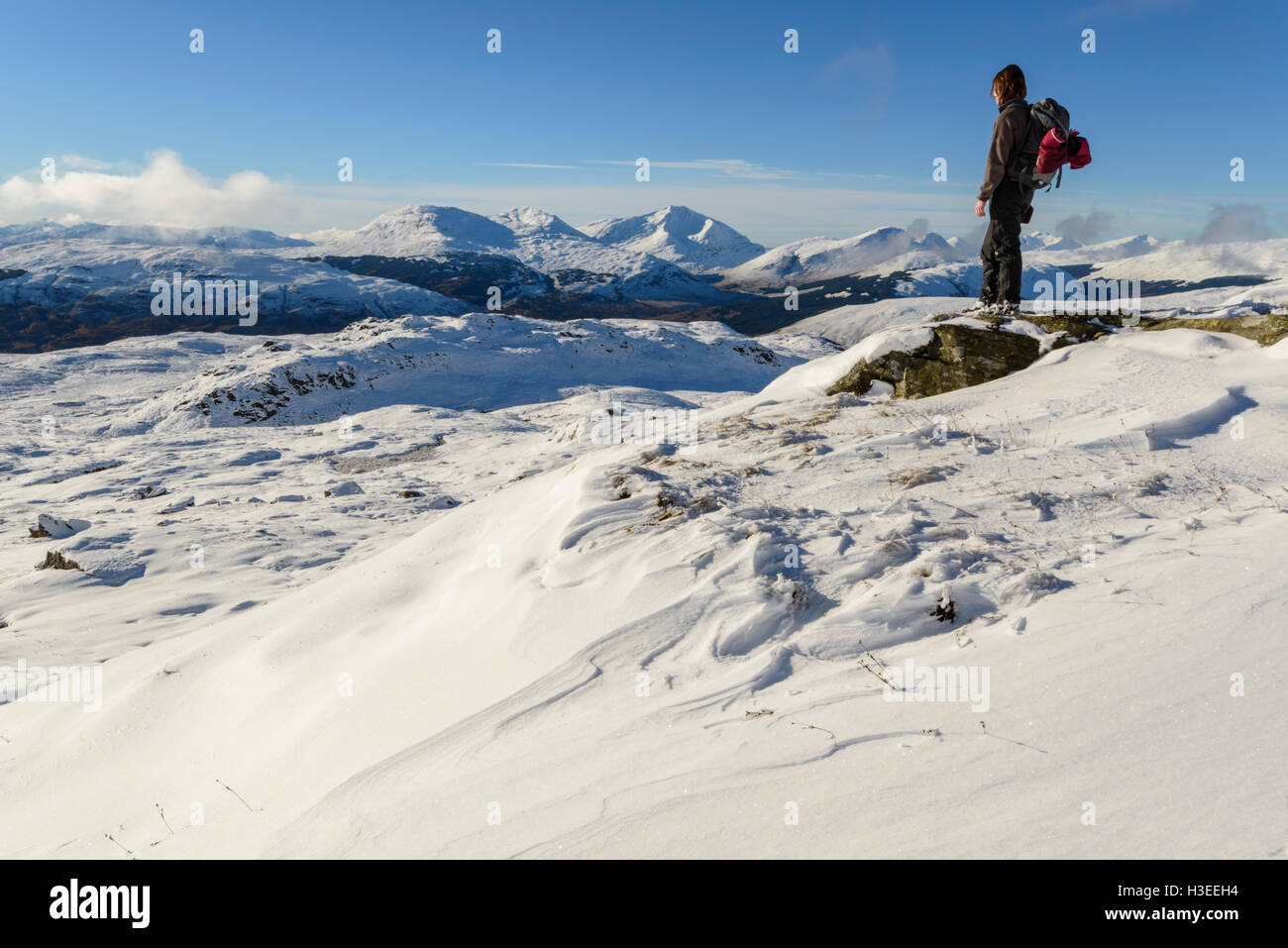 Female hill walker looking towards the snow covered Munro of Ben Lui ...