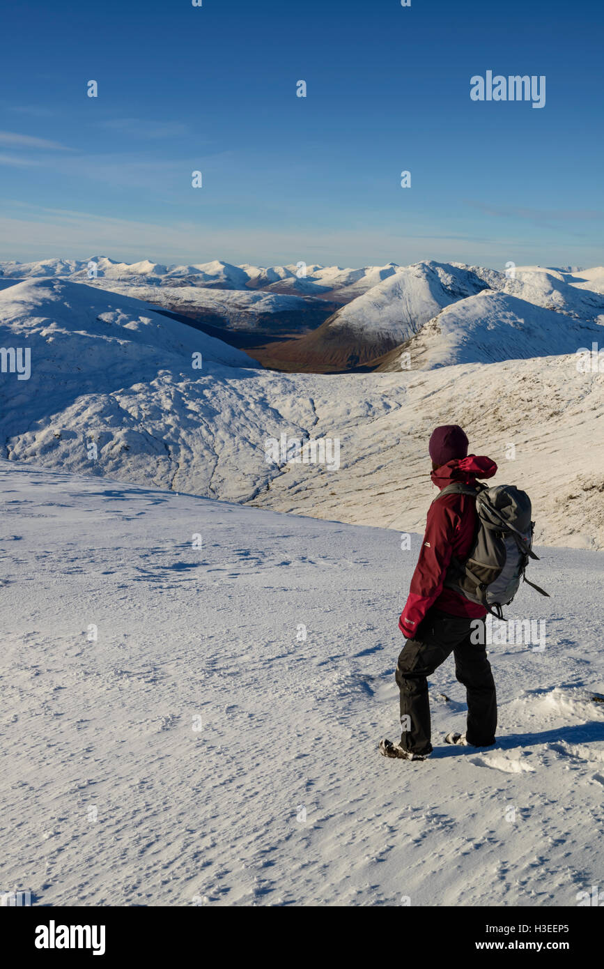 Female hill walker admiring the winter view from the summit of the ...