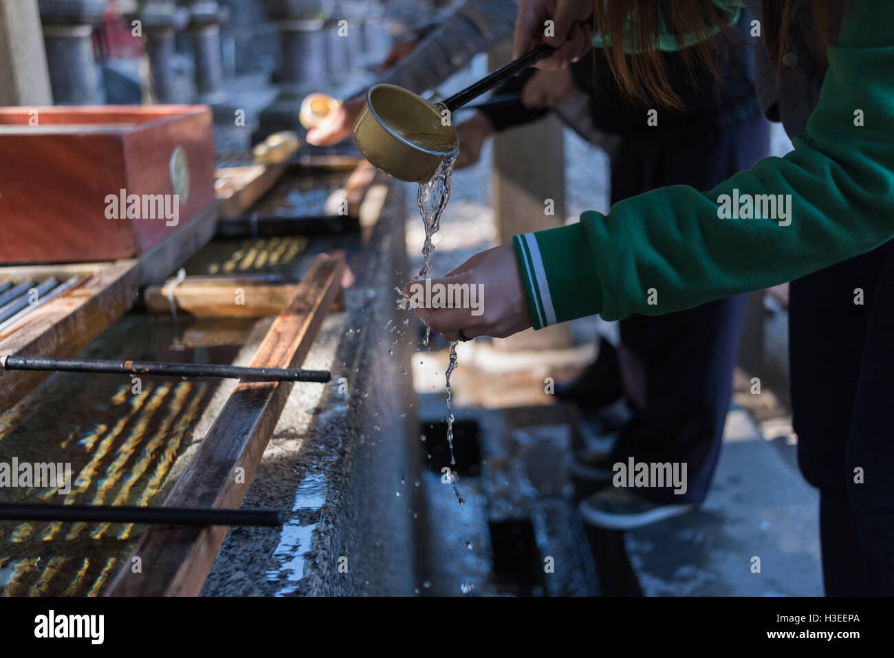 Tourist lady wash hand before entry to Japanese temple Stock Photo - Alamy