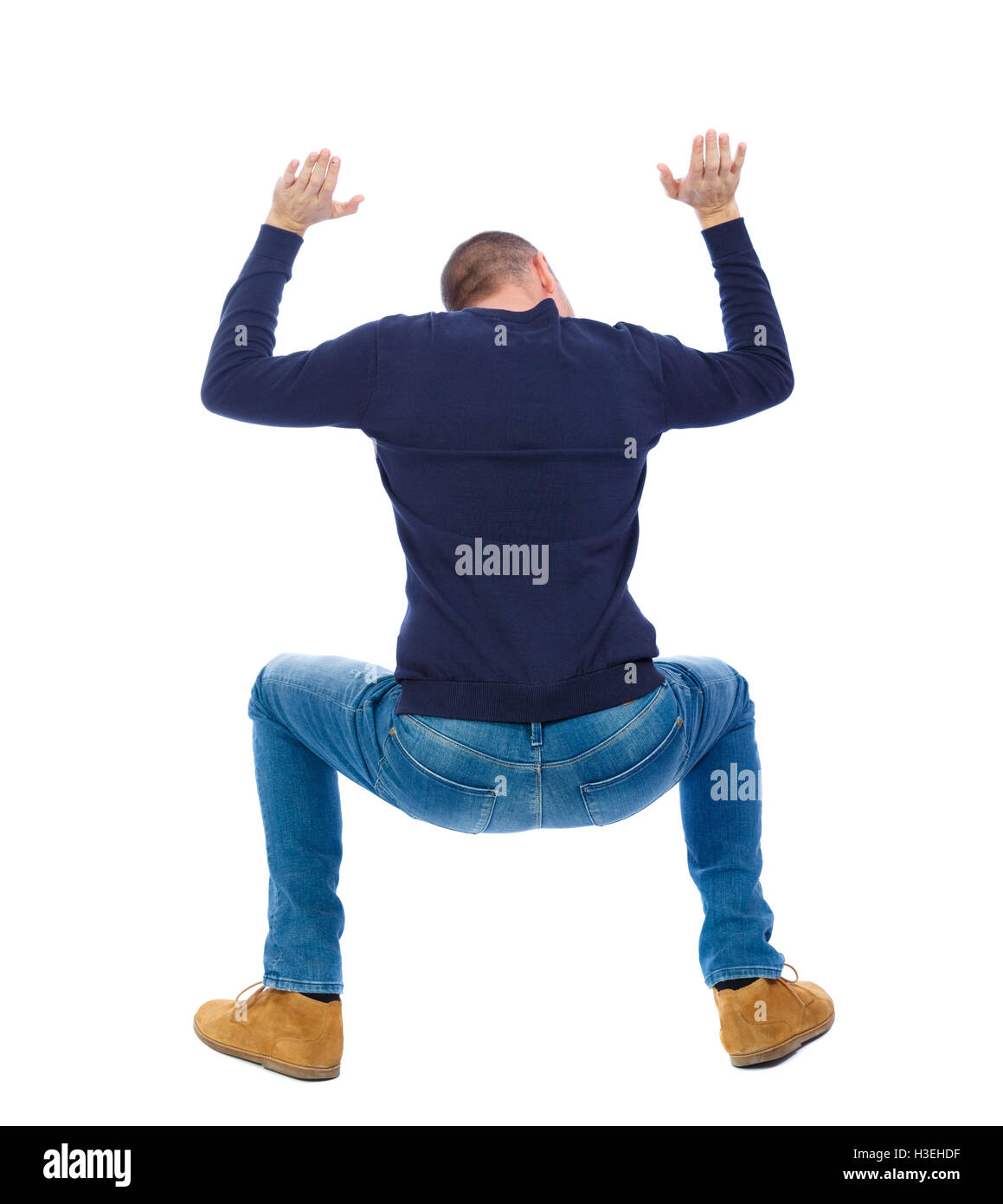 back view. man protects hands from what is falling from above. Man ...
