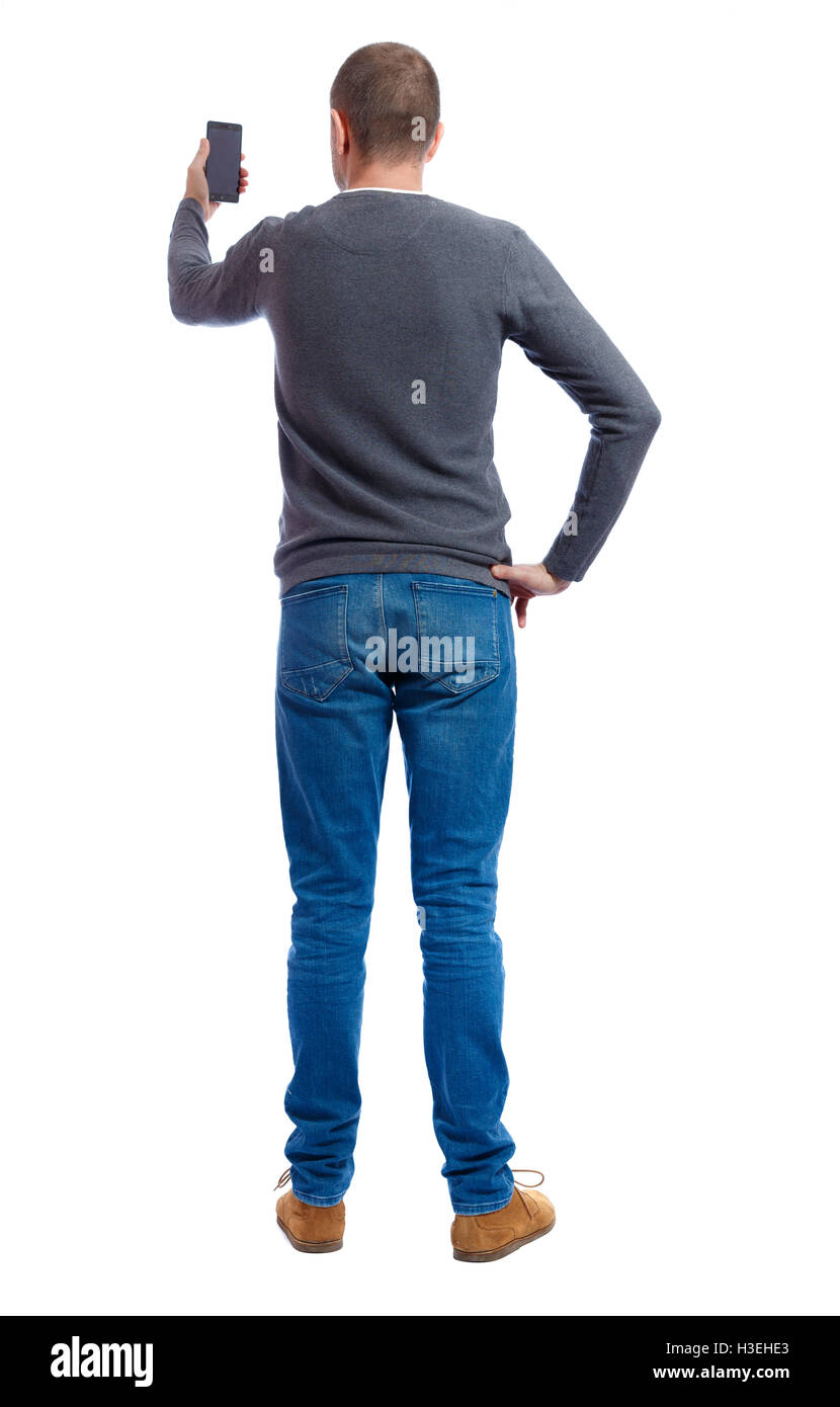 back view of standing young man and using a mobile phone. girl watching ...