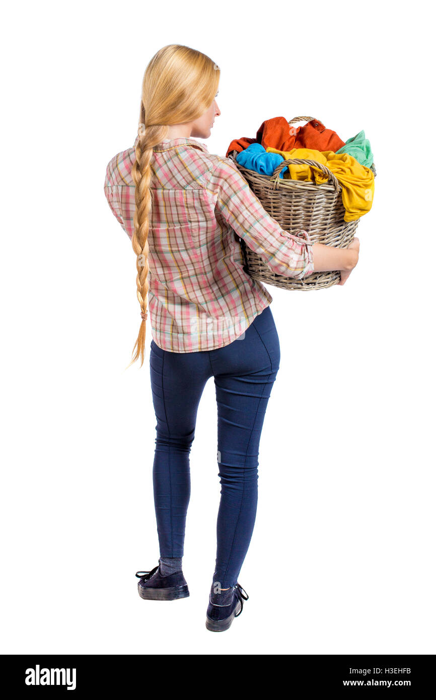 Back view of woman with basket of dirty laundry. girl is engaged in ...