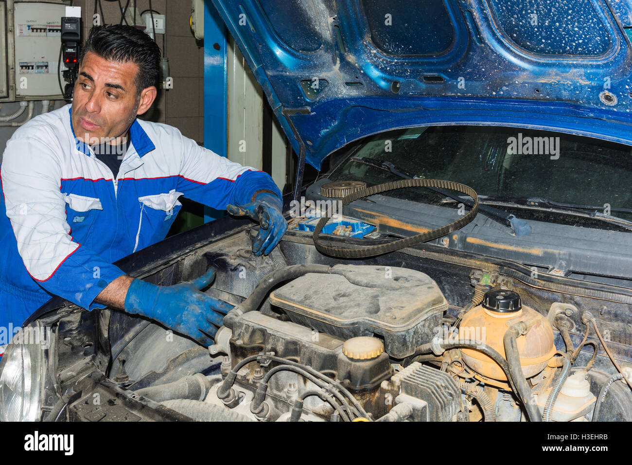 Car mechanic fixing an engine in his garage. copy space Stock Photo - Alamy