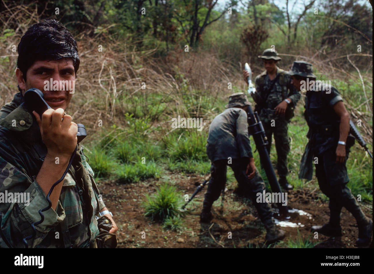 El Salvador, 1986. Government soldiers on patrol in in Morazan Province fire mortar shells at ...