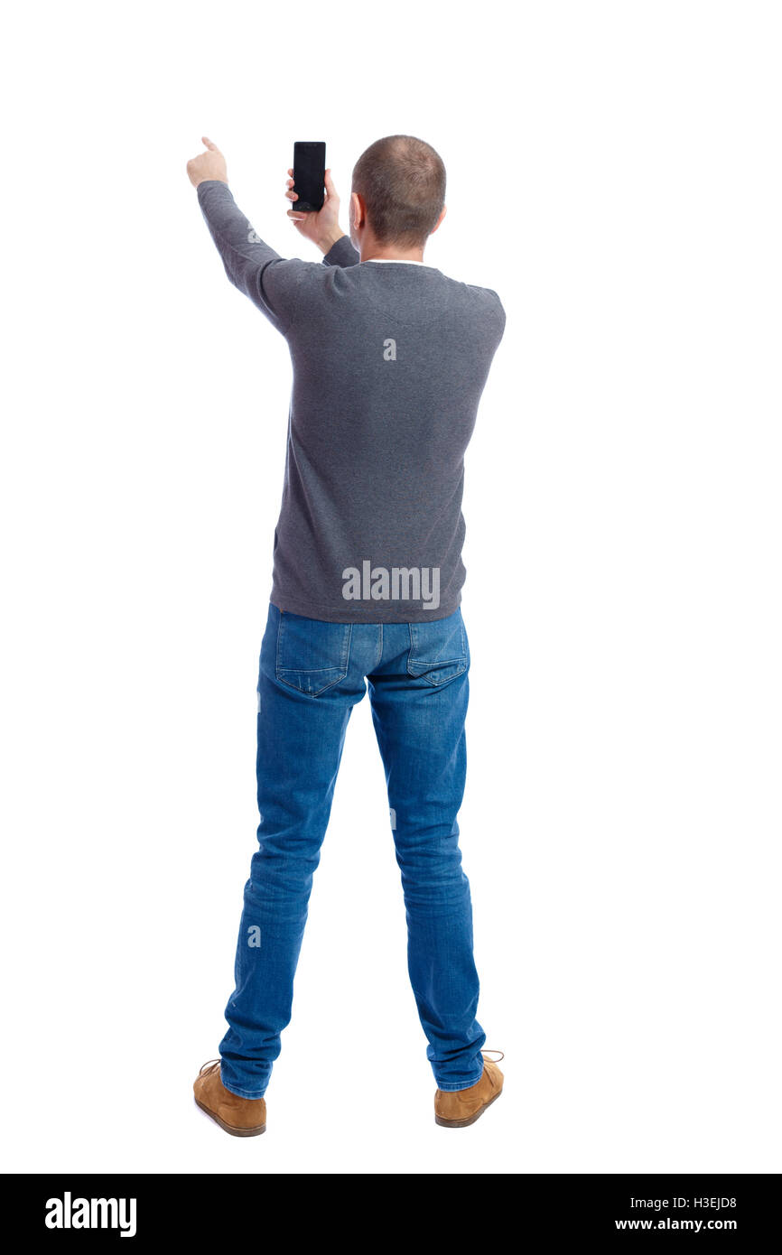 back view of standing young man and using a mobile phone. girl watching ...