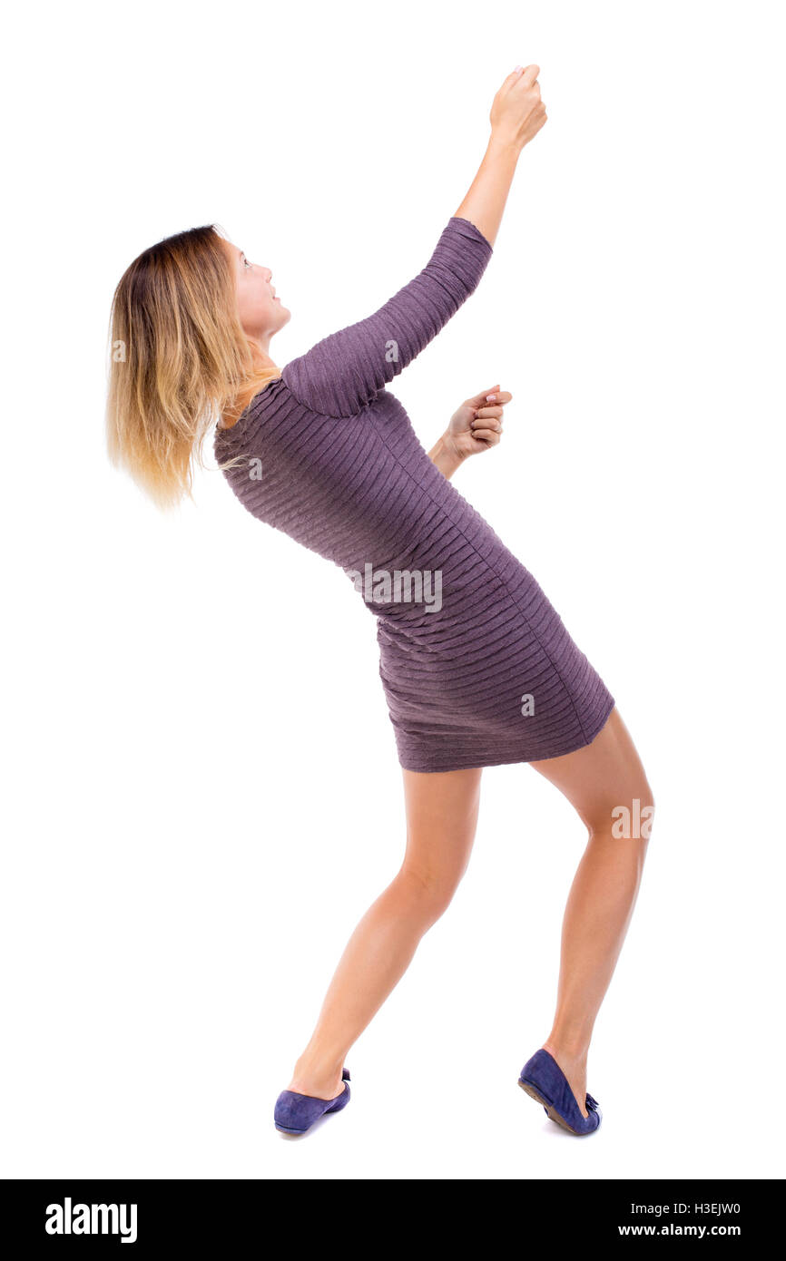 back view of standing girl pulling a rope from the top or cling to ...