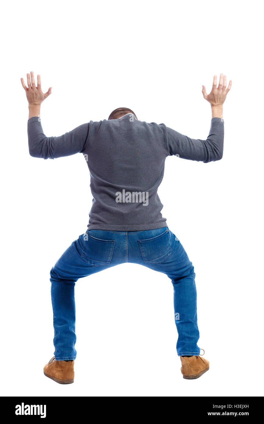 back view. man protects hands from what is falling from above. Man ...