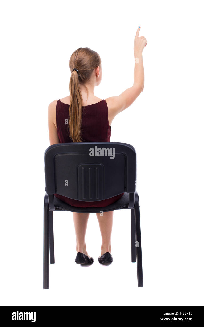back view of woman sitting on chair and pointing. Rear view people ...