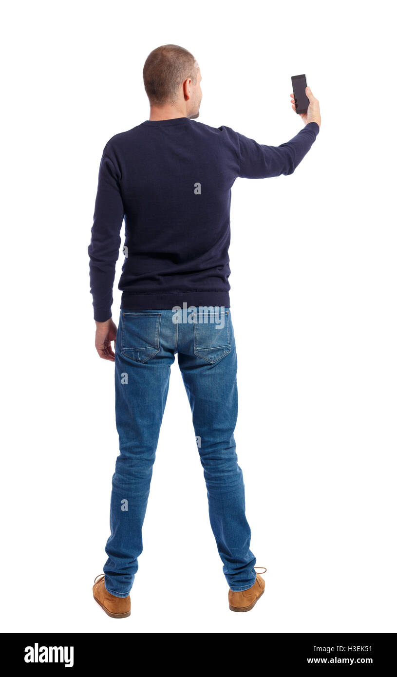 back view of standing young man and using a mobile phone Stock Photo ...