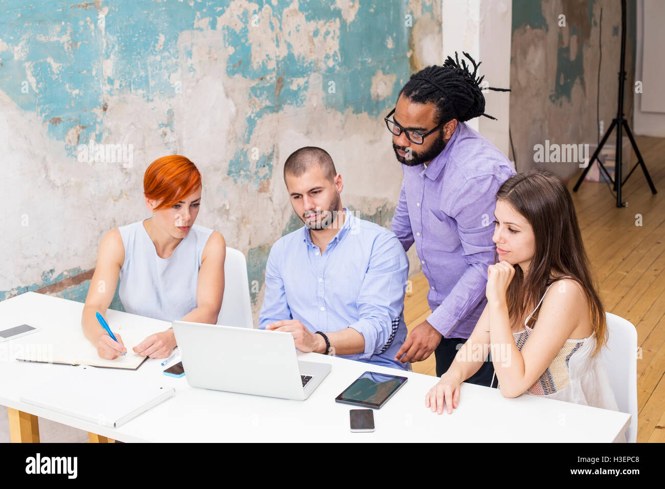 Young multiracial people working by the desk in the grunge office Stock ...