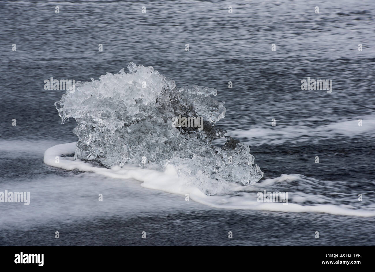 Small ice block at the beach in the evening near river Jokulsa at ...