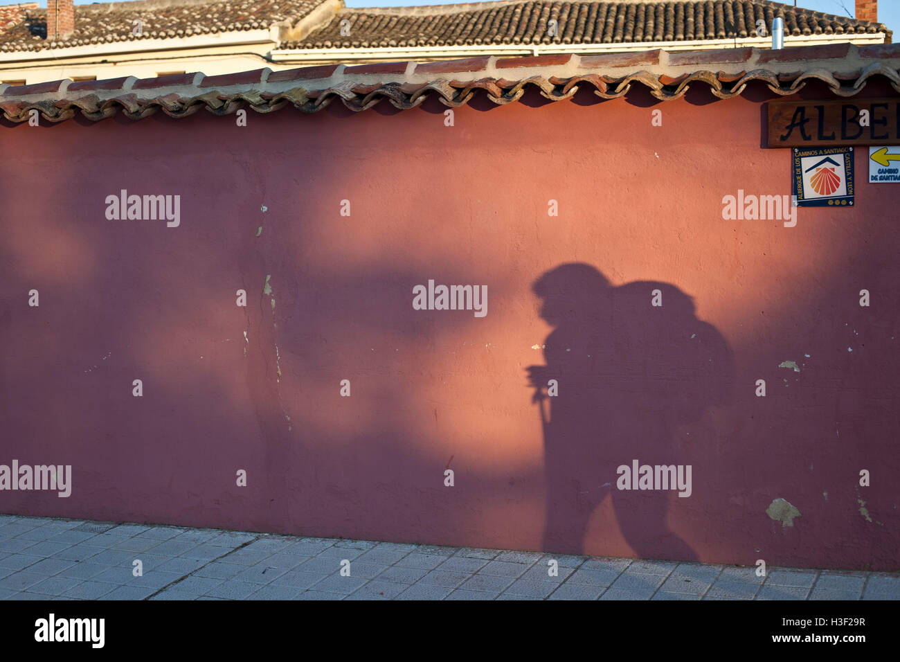 Shadow of a pilgrim early morning on a wall along the Camino de ...