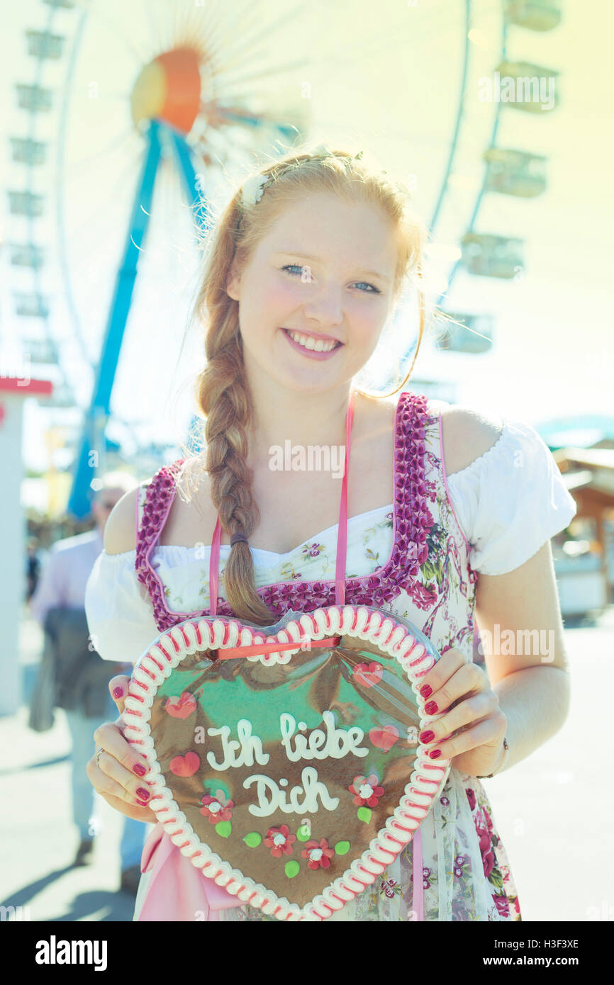 German girl wearing a Dirndl and holding a traditional Oktoberfest's ...