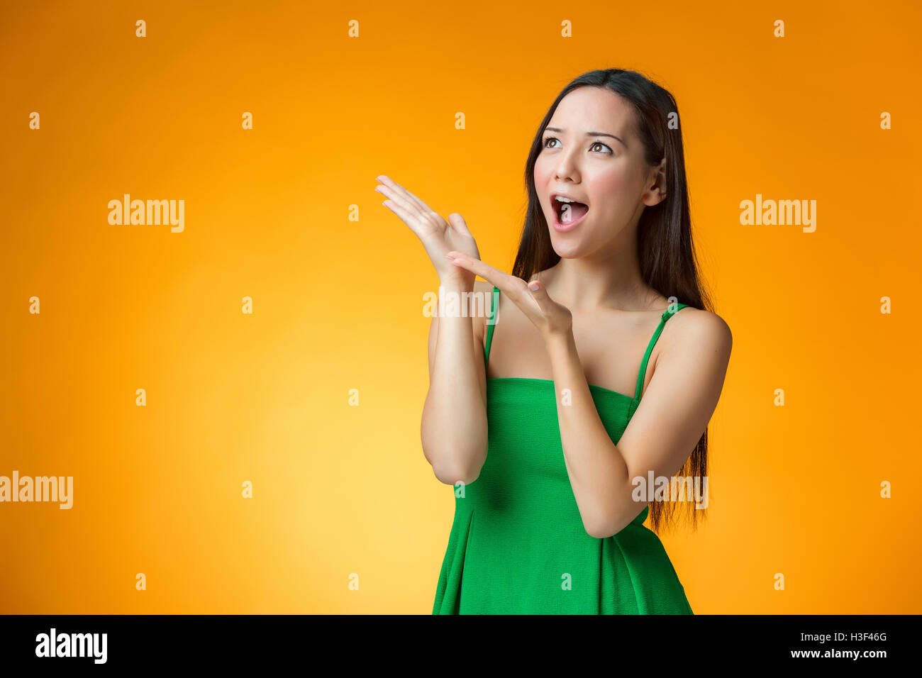 The surprised Chinese girl on yellow background Stock Photo - Alamy