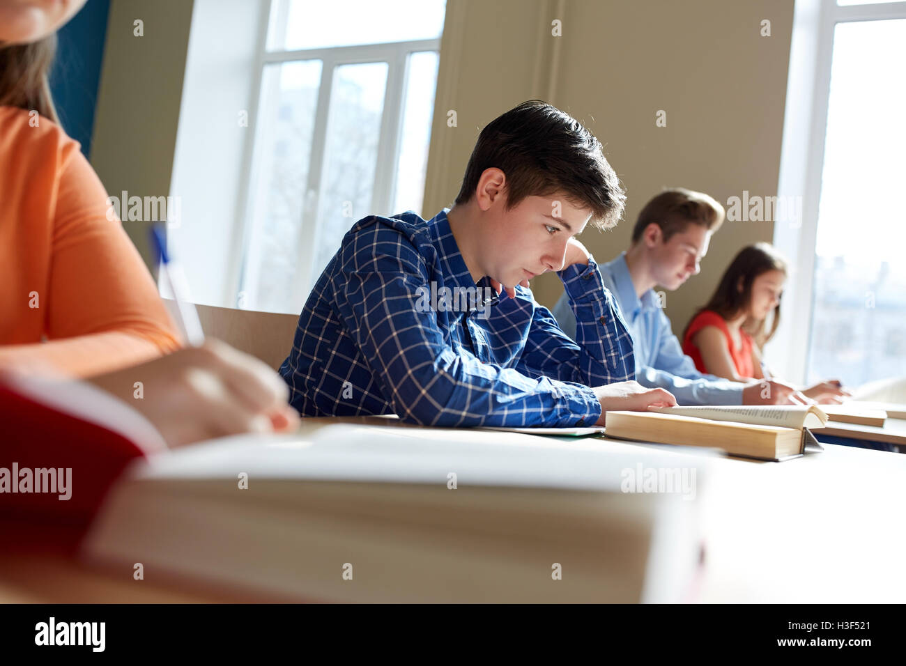 group of students with books writing school test Stock Photo - Alamy