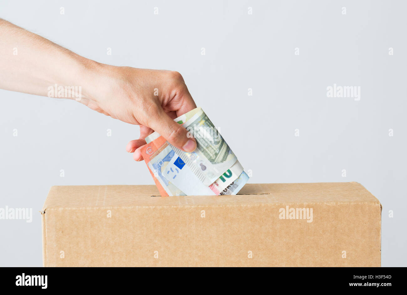 man putting euro money into donation box Stock Photo - Alamy
