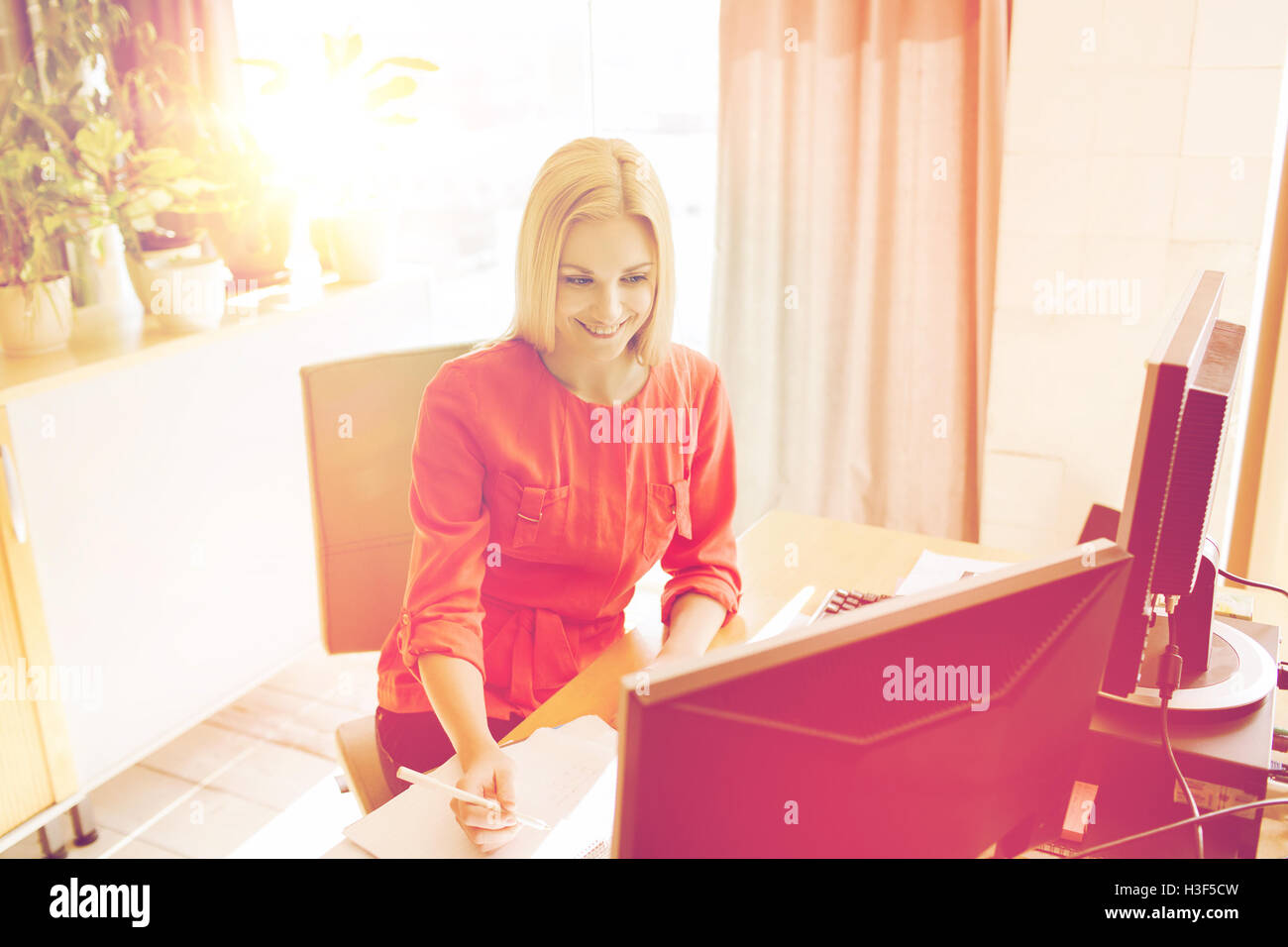 happy creative female office worker with computers Stock Photo - Alamy