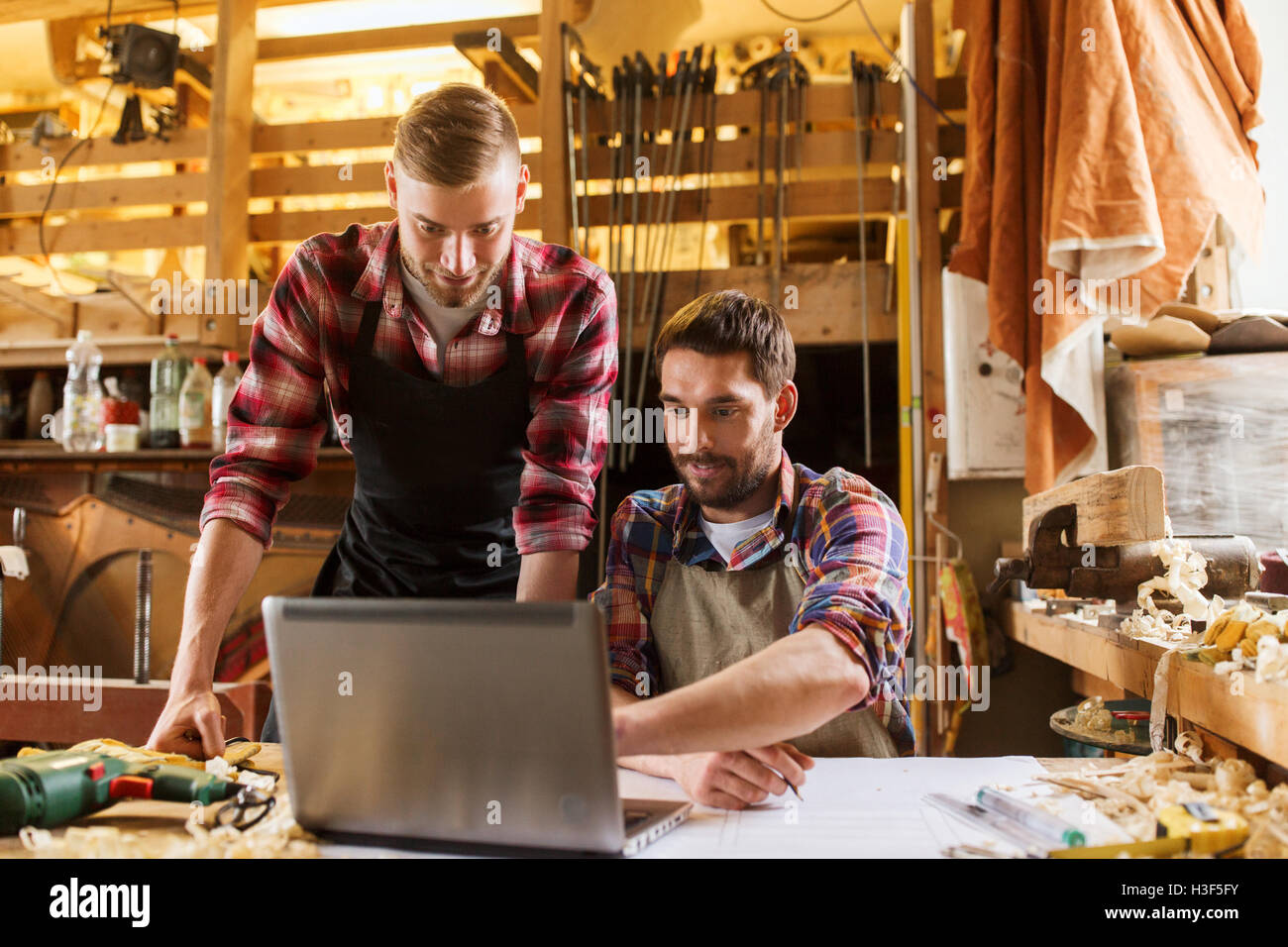 carpenters with laptop and blueprint at workshop Stock Photo - Alamy