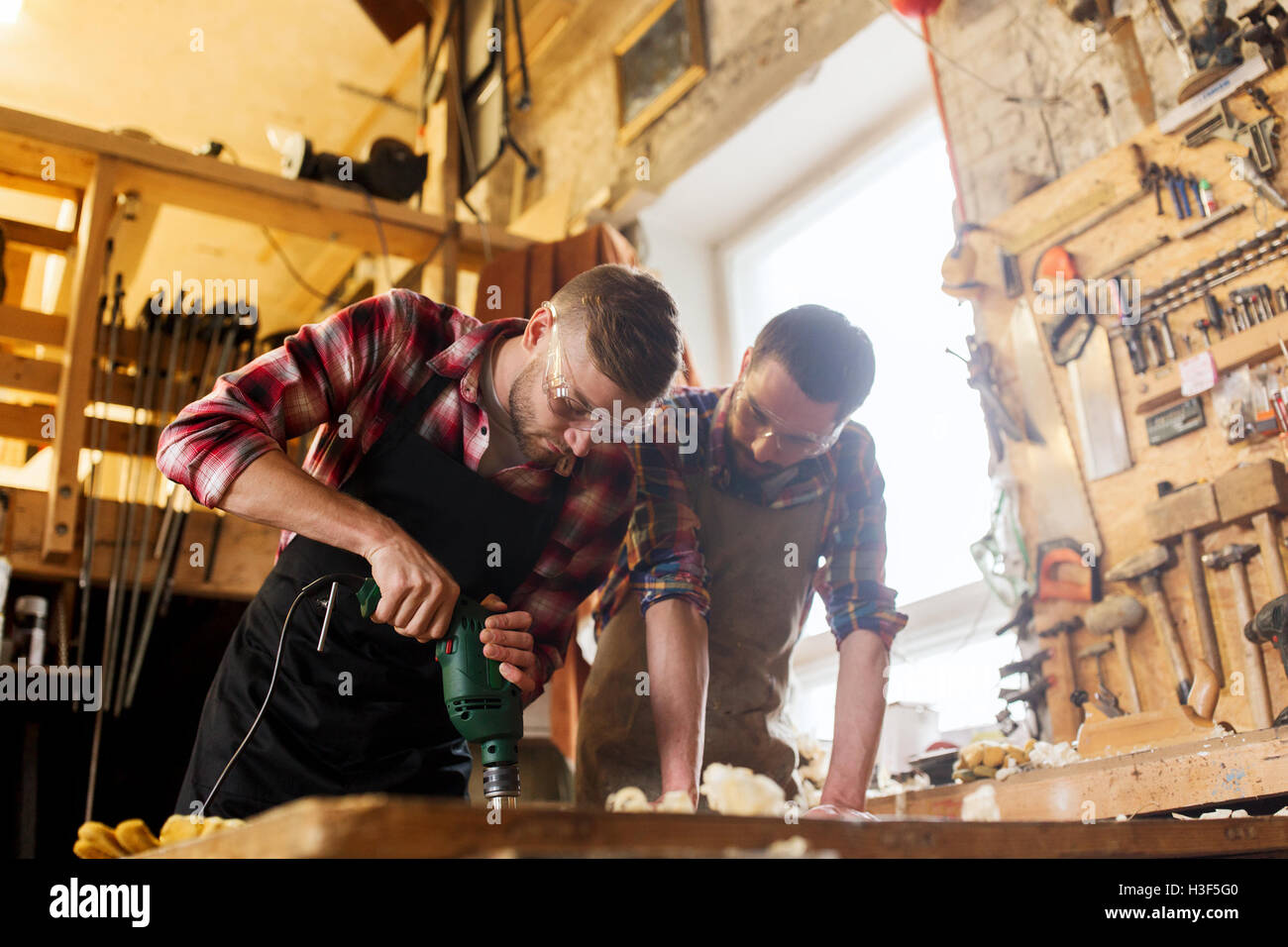 carpenters with drill drilling plank at workshop Stock Photo - Alamy